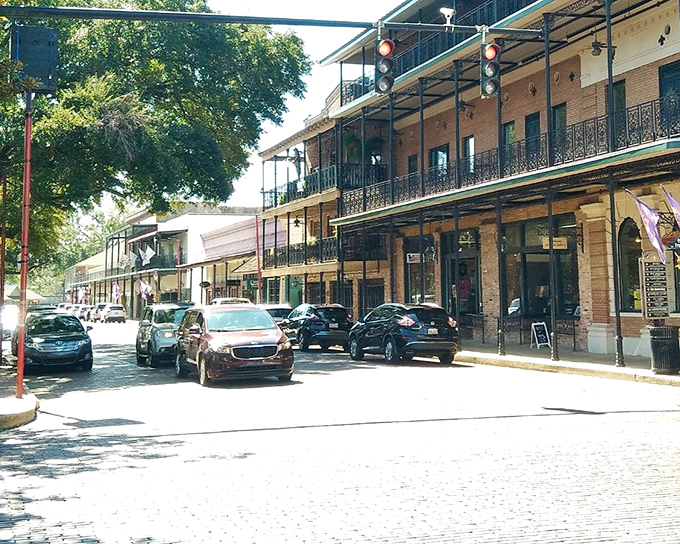The historic district's buildings stand shoulder to shoulder like old friends, sharing secrets across a street that's seen everything from horse-drawn carriages to hybrid SUVs.