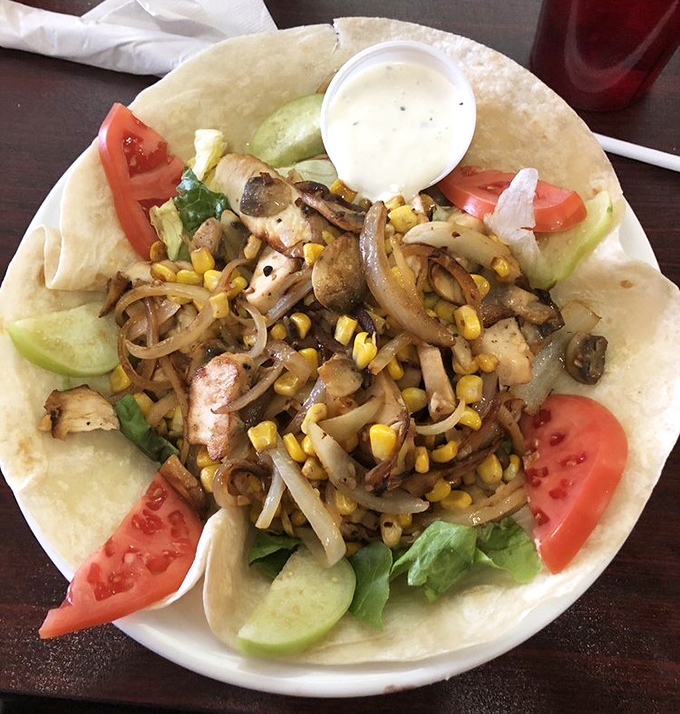 A grilled chicken salad that makes eating healthy feel like cheating—served in a tortilla bowl because why not?