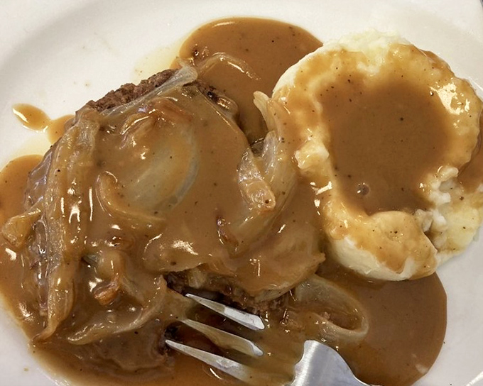 Hamburger steak smothered in gravy and onions with a side of mashed potatoes&mdash;the kind of plate that makes you want to hug the cook.