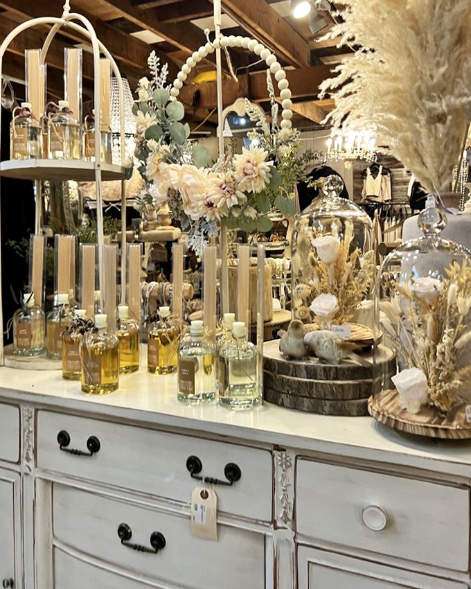 Delicate dried flowers and amber bottles create an ethereal display atop a distressed white dresser&mdash;farmhouse elegance at its finest.