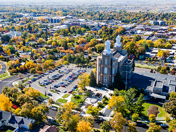 Logan's autumn aerial view reveals a city embraced by golden trees and mountain majesty, where urban planning and natural beauty achieve perfect harmony.