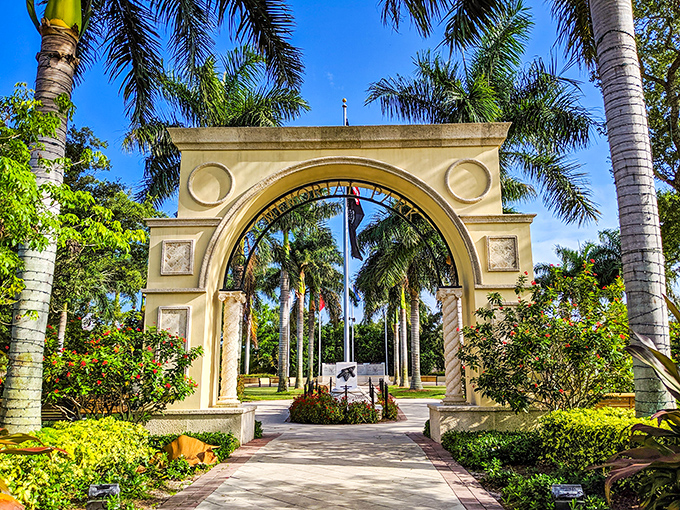 This elegant archway in Memorial Park frames a palm-lined path that feels like entering a secret tropical garden in the heart of Stuart.