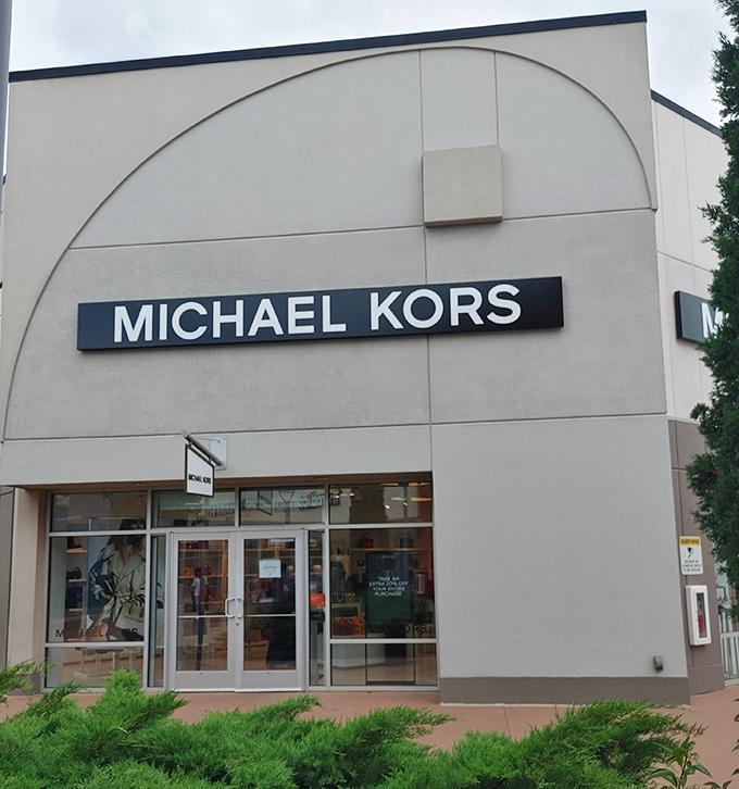 Michael Kors' elegant storefront promises accessible luxury where handbags whisper "treat yourself" in their most persuasive voices.
