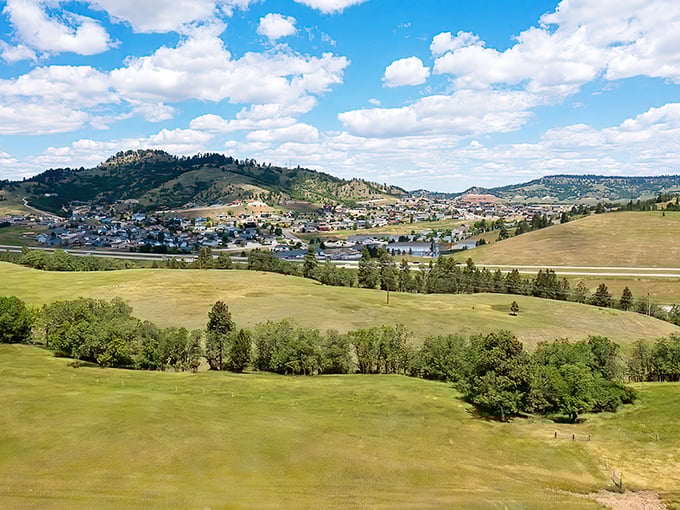 Rolling hills cradle a distant town, showcasing the breathtaking landscape that makes South Dakota's prairies anything but plain.