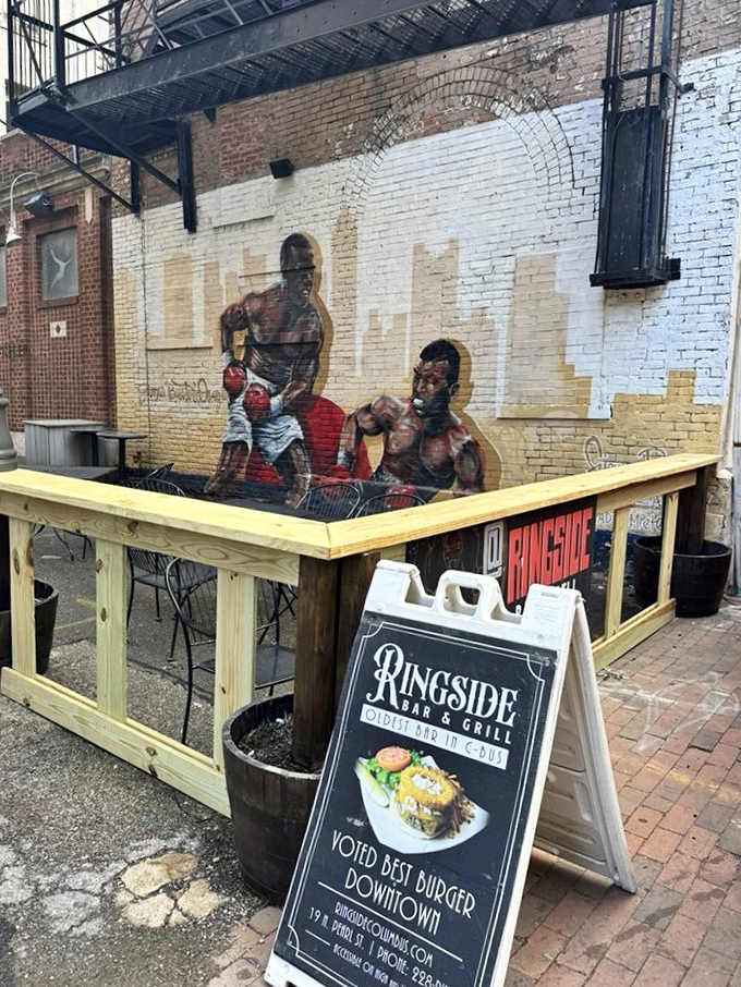 A boxing mural watches over outdoor diners, a colorful reminder that this restaurant pulls no punches when it comes to flavor.