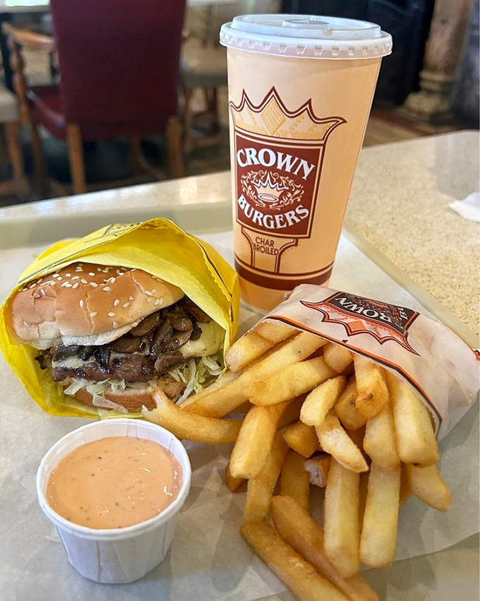 The complete Crown Burgers experience: a pastrami-topped masterpiece, golden fries, and that signature sauce. Happiness on a tray.