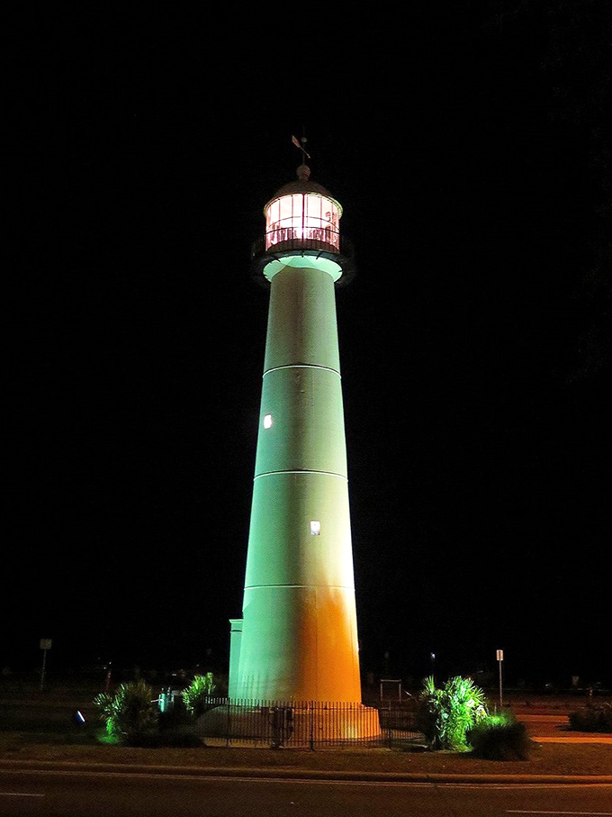 By night, the illuminated lighthouse transforms into a glowing sentinel, standing watch over Biloxi's moonlit coastline.