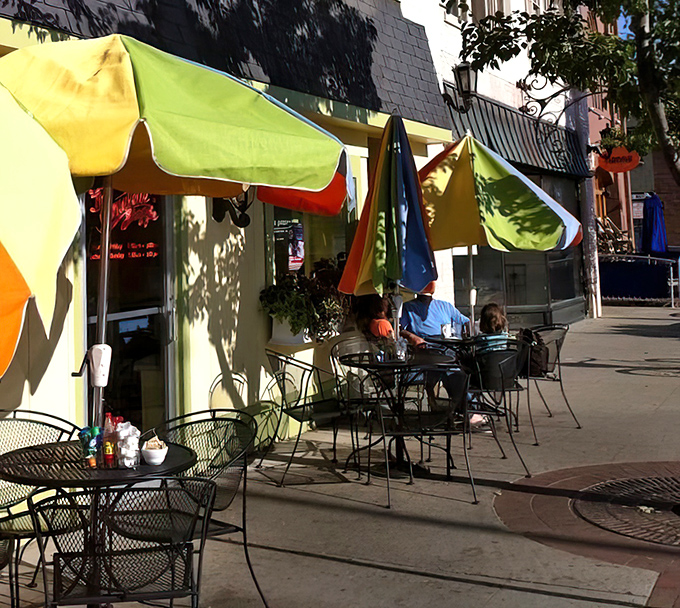 Colorful umbrellas create an outdoor oasis where summer breezes complement your coffee and Michigan sunshine seasons your meal.