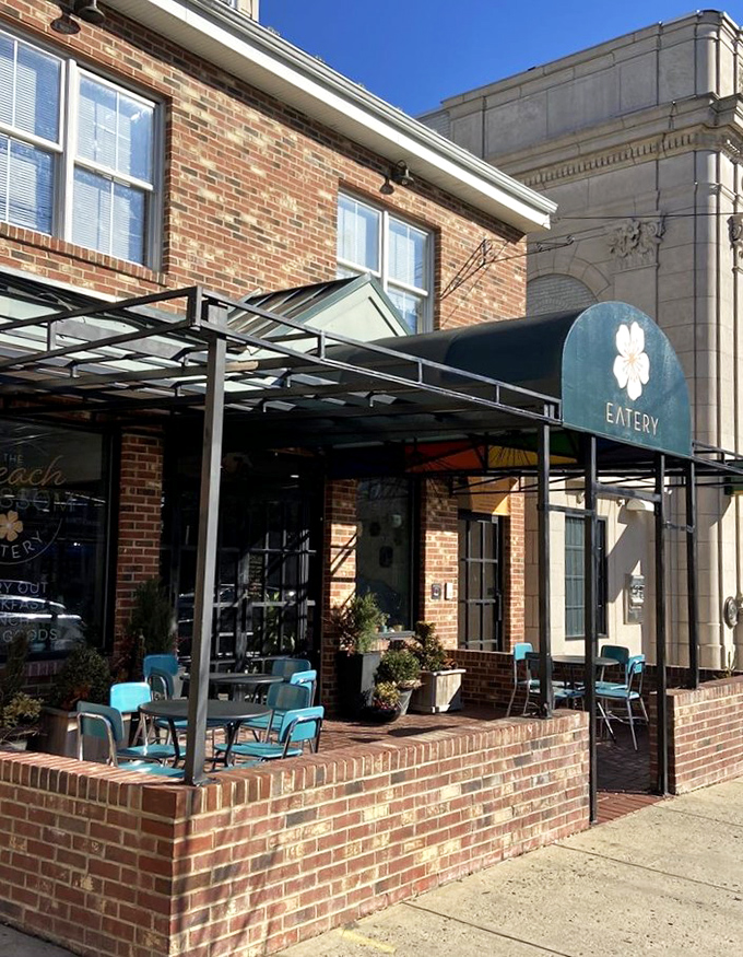 The outdoor seating area, with its cheerful turquoise chairs, offers al fresco dining that elevates people-watching to an Olympic sport.