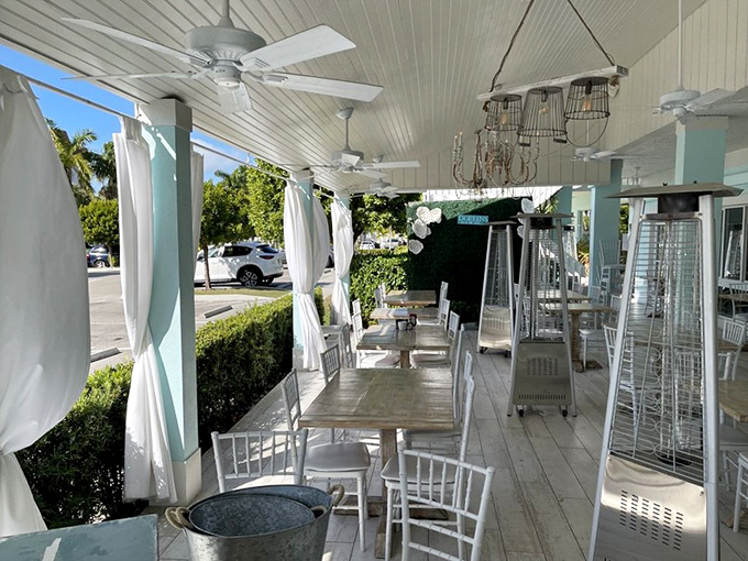 The outdoor patio offers Florida dining at its finest—ceiling fans, white curtains, and the promise of breakfast with a side of gentle breeze.