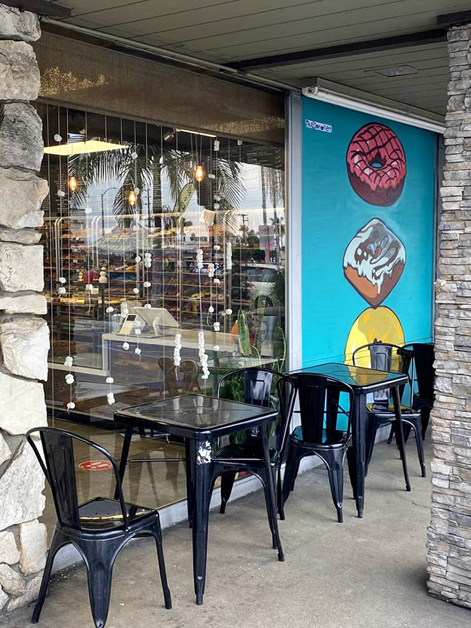 Outdoor seating with playful donut art lets you enjoy your spoils while contemplating immediate return visits shamelessly.