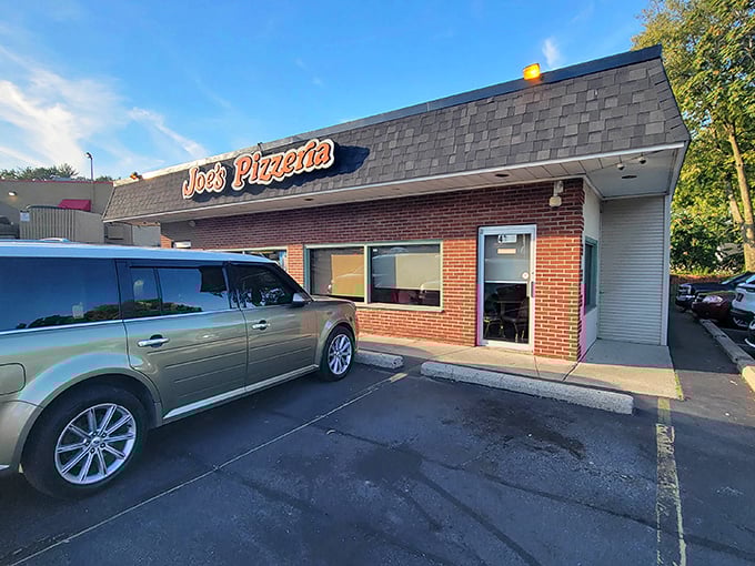 Morning light catches Joe's Pizzeria in a moment of quiet anticipation, like a theater before the show. Soon, the parking lot will fill with pizza seekers.