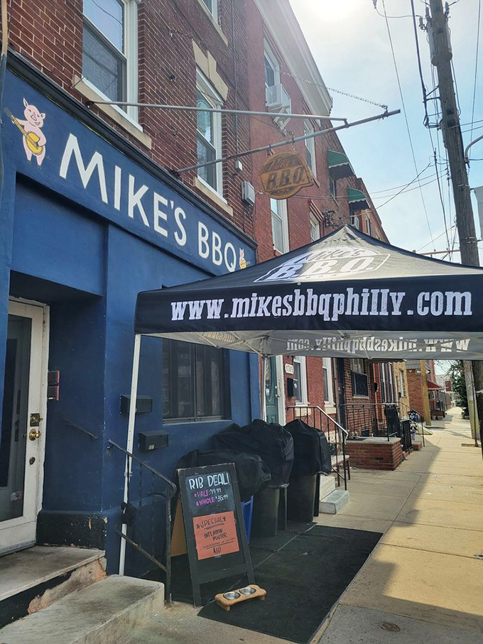 The sidewalk view tells the whole story: blue storefront, serious smoker, and a sign promising deals on ribs. What more motivation do you need?