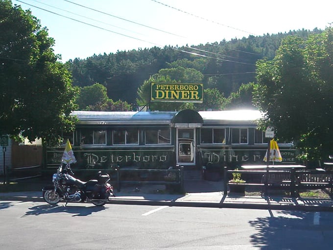 Morning light bathes the iconic green Worcester Lunch Car, while the surrounding hills remind you this is quintessential New Hampshire dining.