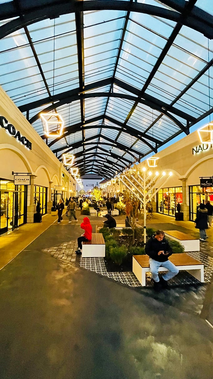 Evening shopping takes on a magical quality as the outlets transform into a twinkling retail wonderland under the glass canopy.