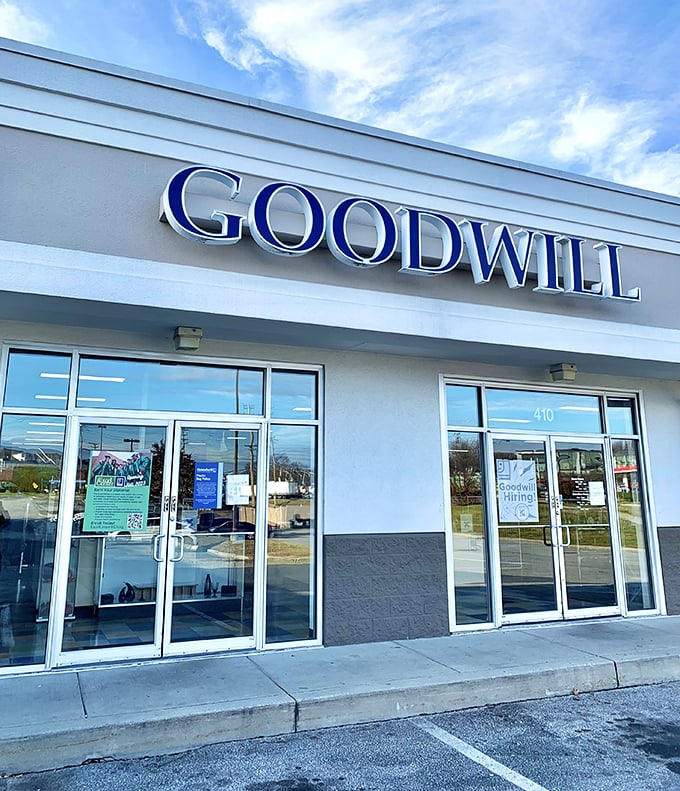 Morning light bathes the Goodwill entrance in possibility. Behind these doors, thirty-five dollars can transform your wardrobe, home, and outlook.