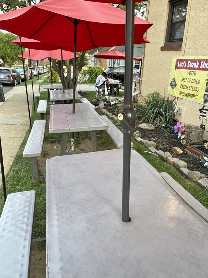 Al fresco sandwich enjoyment under cheerful red umbrellas. Because some experiences are too good to be contained indoors.