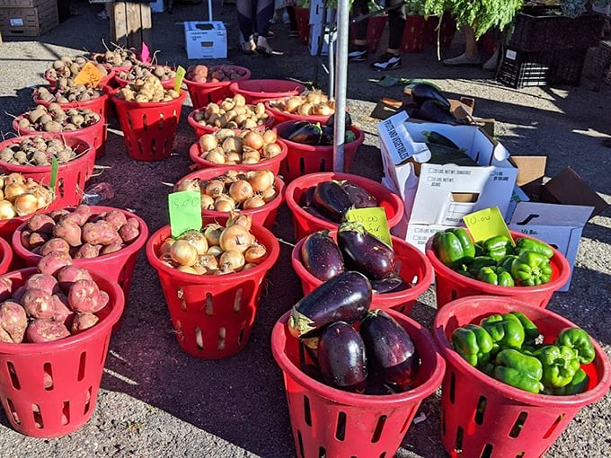 Fresh produce overflowing from red baskets offers vegetables that actually taste like they grew in soil instead of a laboratory.