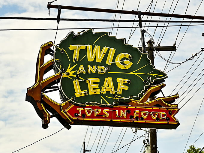 The vintage neon sign glows like a beacon for hungry travelers, its leaf-shaped promise of being "Tops in Food" a bold claim that generations of customers have verified.