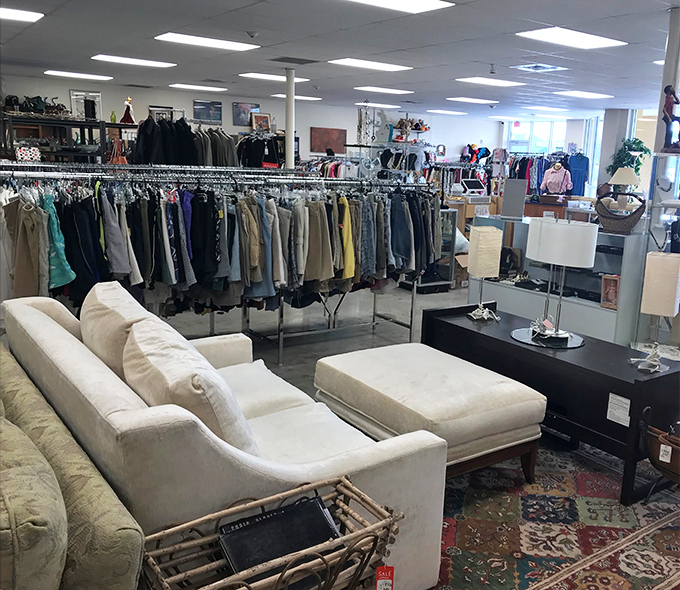 The clothing section, artfully arranged like a boutique where your wallet won't need therapy afterward. That white sofa? Just waiting for someone brave enough to own it.