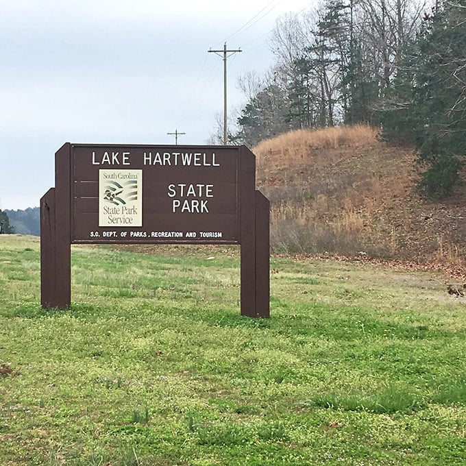 The unassuming gateway to paradise – where that simple brown sign marks the boundary between ordinary life and extraordinary memories.