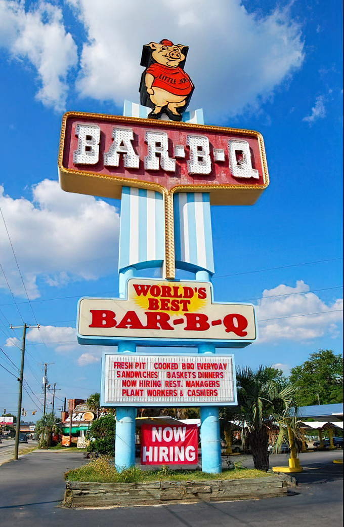 That famous pig mascot stands proudly atop the vintage sign &ndash; a beacon of barbecue excellence visible from blocks away, guiding the hungry home.
