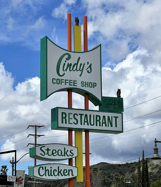 The vintage sign stands tall against the California sky, a beacon of breakfast hope that's been guiding hungry travelers for decades.