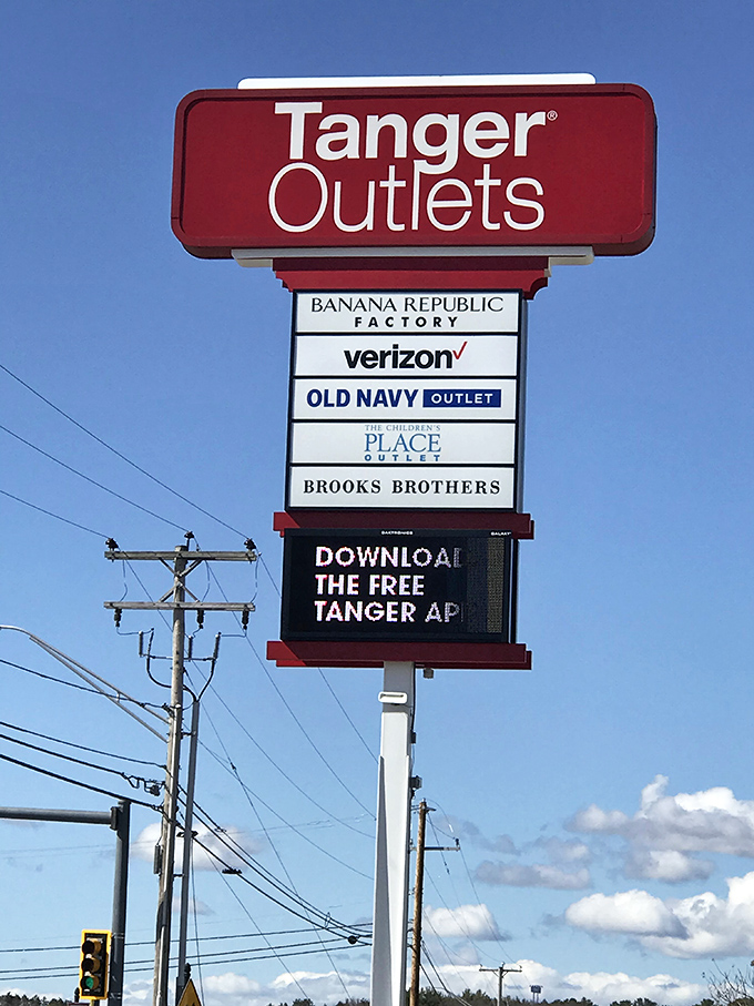 The Tanger sign stands tall against blue skies, a beacon calling bargain hunters from across New England's highways.