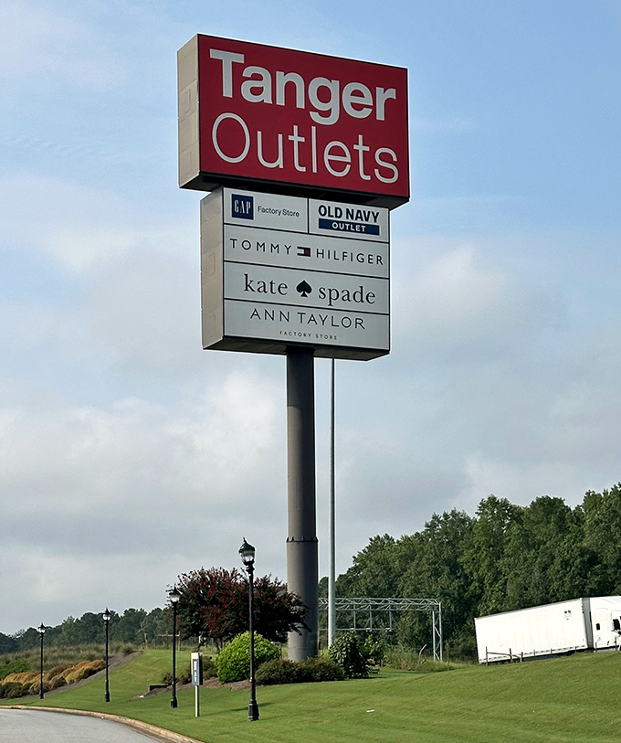 The towering sign stands like a retail lighthouse, guiding bargain hunters safely to the shores of discounted designer goods.
