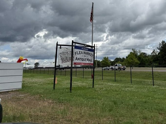 The market's modest sign stands against dramatic Mississippi skies, giving no hint of the wonderland of treasures waiting just beyond the fence.