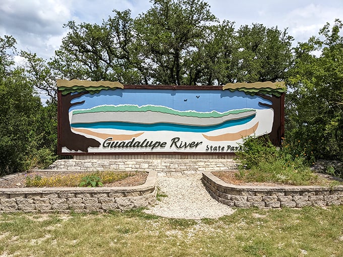 The entrance sign welcomes visitors with artistic flair, a colorful preview of the natural masterpiece waiting beyond.