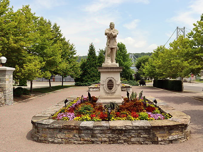 The Simon Kenton statue stands surrounded by flowers, honoring the pioneer while providing a perfect spot for contemplating history or just catching your breath.
