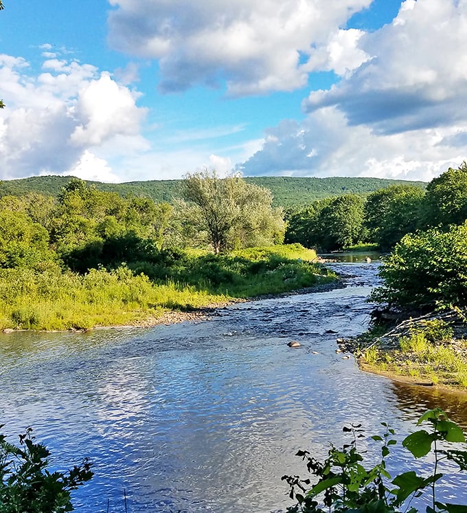 The Sugar River meanders through Claremont like a liquid timeline, connecting past to present while reflecting blue skies and green hills in its gentle current. 