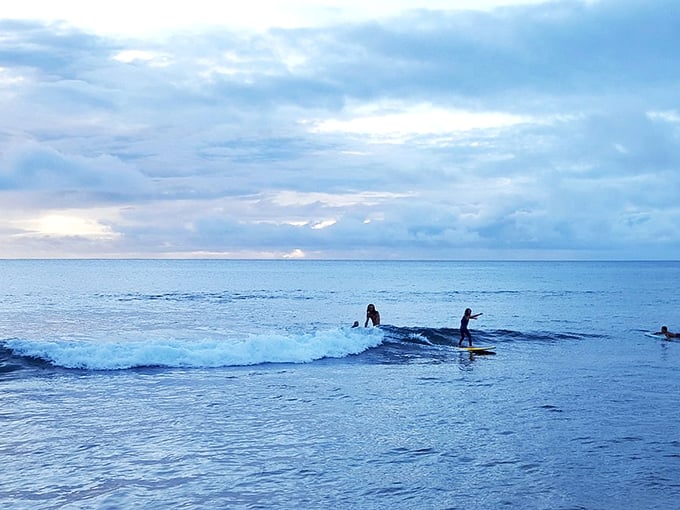 Sunset surf session: When locals make wave-riding look effortless while the rest of us struggle with inflatable pool toys.