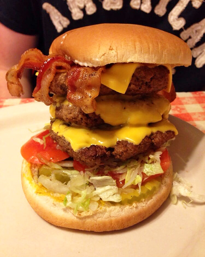 The Mel burger towers dangerously high with double patties, onion rings, and enough cheese to violate several physics laws gloriously.