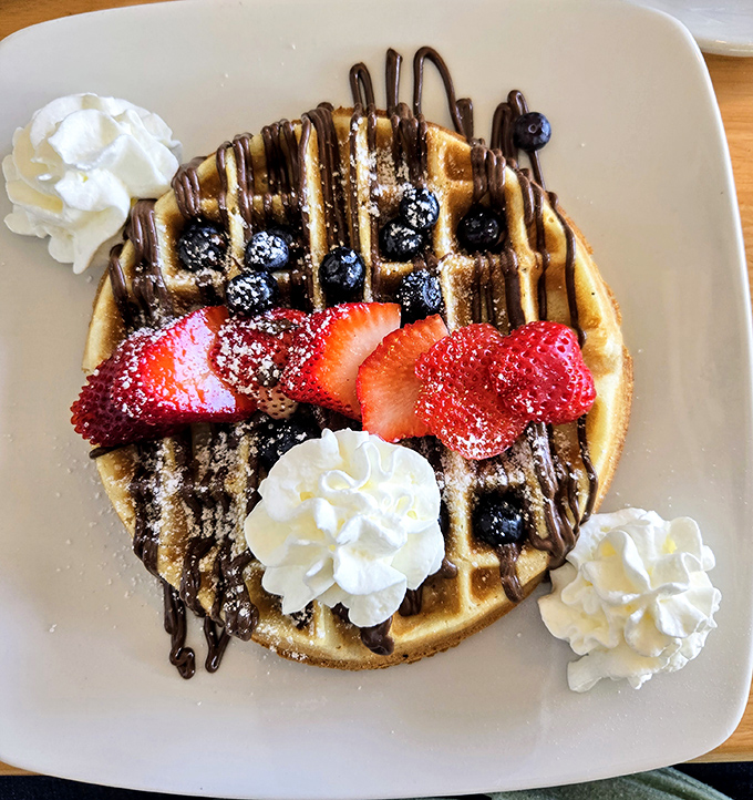 A waffle that's dressed better than most people at a wedding. Fresh berries, chocolate drizzle, and whipped cream create an edible celebration.