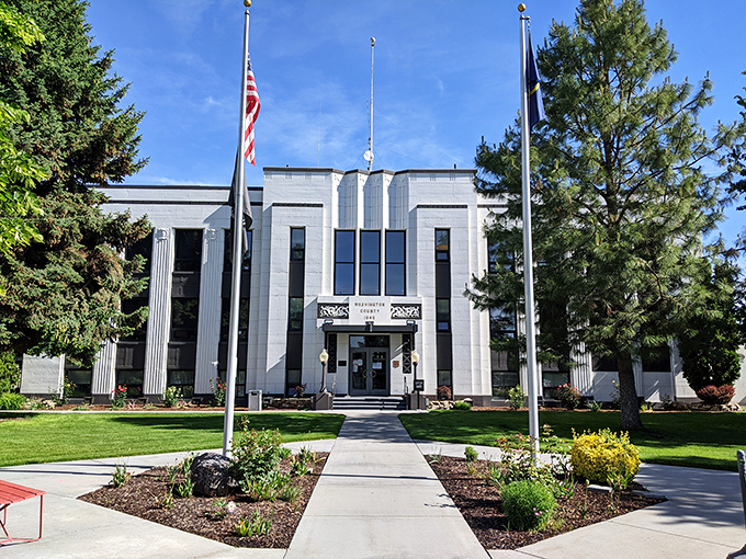 The courthouse lawn stays manicured with pride, because justice apparently appreciates good landscaping and symmetrical flowerbeds.