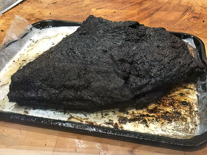 The whole brisket in its natural habitat—gloriously crusted and ready for its close-up. This isn't just meat; it's a 14-hour labor of love.