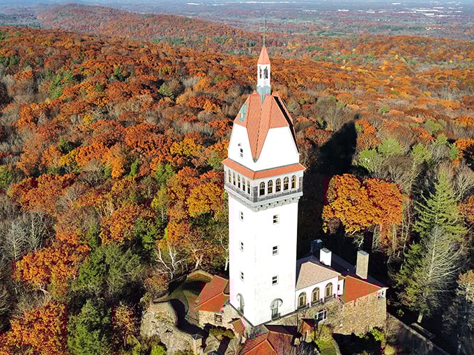 Heublein Tower from above looks like someone dropped a European landmark into New England's autumn inferno. The architect clearly understood the assignment: be dramatic. 