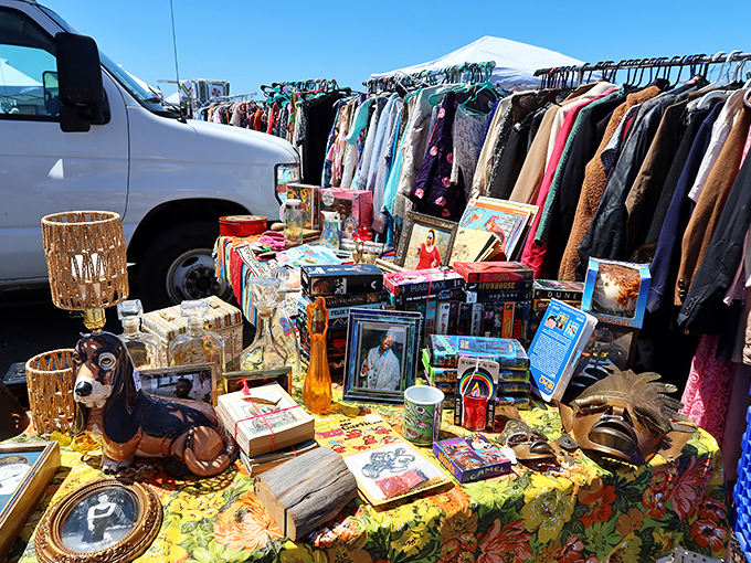 A floral tablecloth showcases an eclectic mix of vintage treasures while racks of clothing stand ready for their second act in someone's wardrobe.