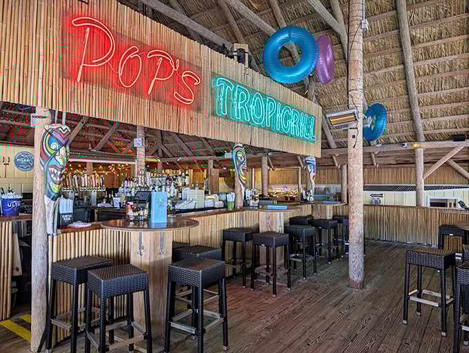 Neon dreams and tropical vibes. Pop's Trop-i-Grill bar area glows with promise &ndash; each stool an invitation to sip something cold while watching the water.