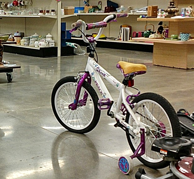 A child's first bike doesn't need to break the bank. This purple and white beauty awaits its next adventure with training wheels still attached for confidence-building.