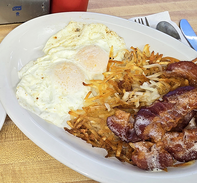 The breakfast of champions&mdash;eggs, hash browns, and bacon arranged like a work of art. Morning perfection on a no-nonsense white plate.