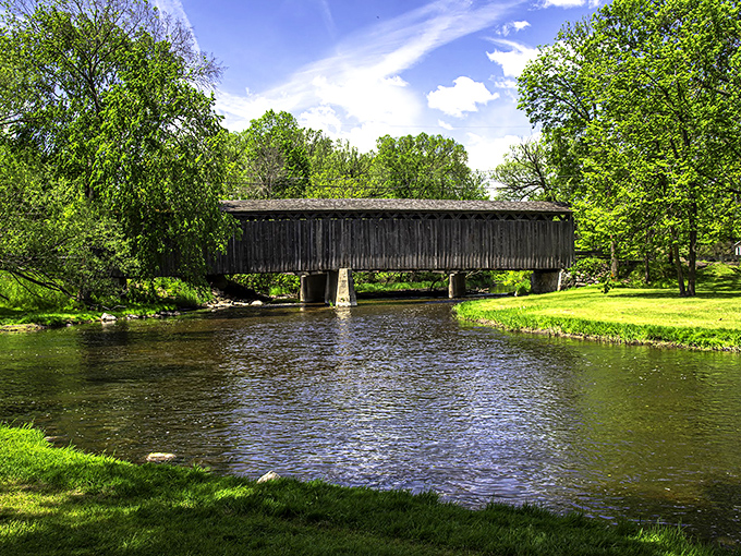 Cedar Creek flows peacefully beneath its namesake bridge, the water's journey continuing while the bridge remains steadfast above.
