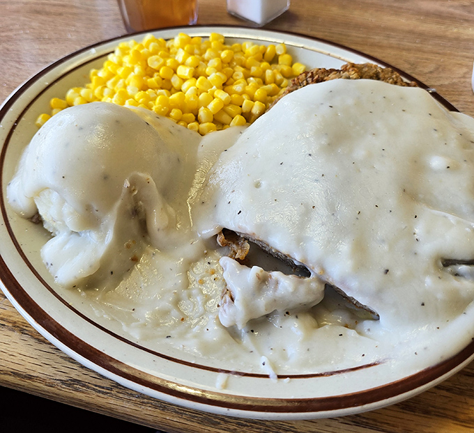Country gravy blankets this chicken-fried steak like a warm Arizona snowfall – rich, peppery, and hiding treasures beneath its surface.