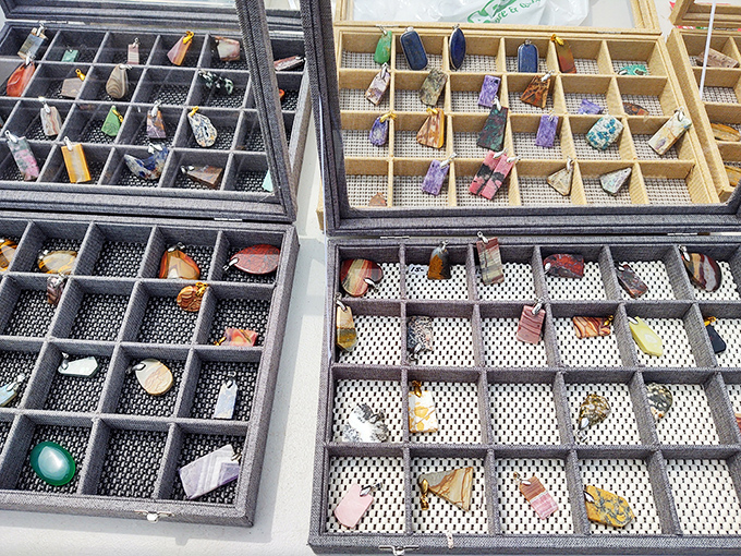 Gemstones and pendants arranged like a treasure map. Each tiny compartment holds someone's future statement piece or conversation starter.