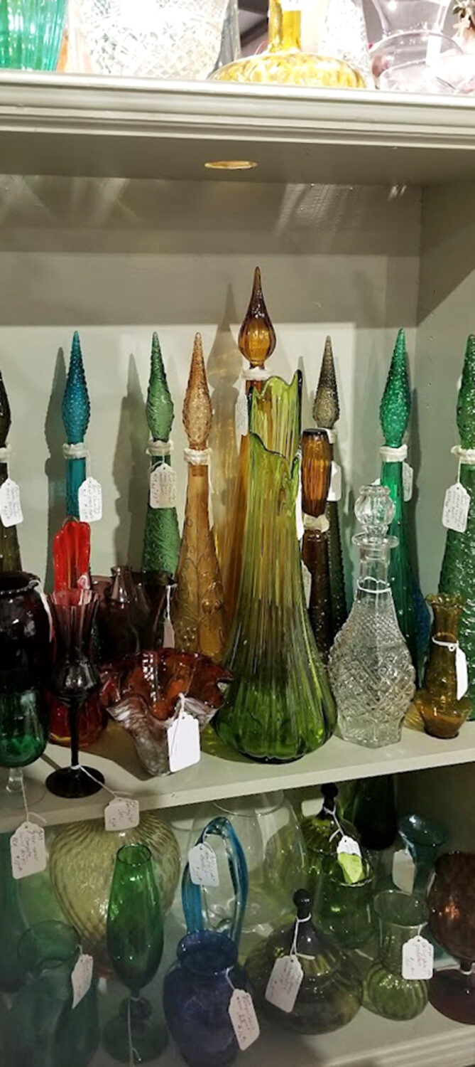 The glass forest where vintage decanters stand tall. Each colorful vessel once the pride of someone's bar cart, now awaiting new cocktail adventures.