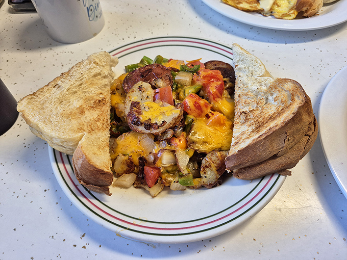 An omelet that refuses to be contained by conventional boundaries, spilling its colorful treasures between two slices of perfectly toasted bread. Breakfast rebellion at its finest.