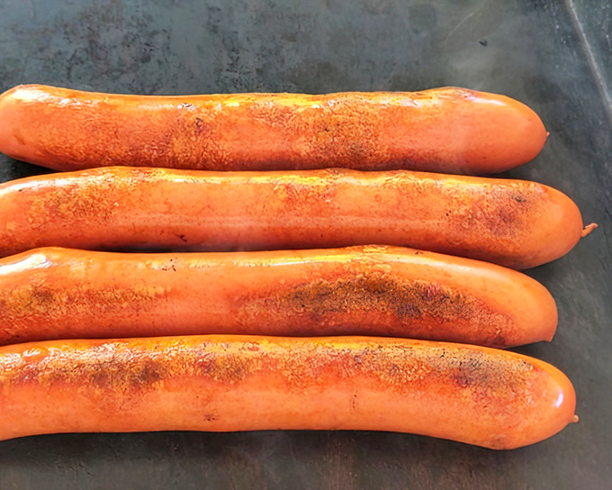 Four dogs on the grill, each one destined to make someone's day significantly better than it started.