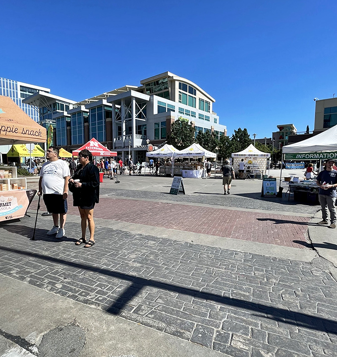 The market sprawls across Aksarben Village's brick plaza, creating a temporary food metropolis that vanishes by afternoon.